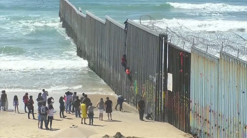 Migrants in Mexico climb over border fence | SBS News